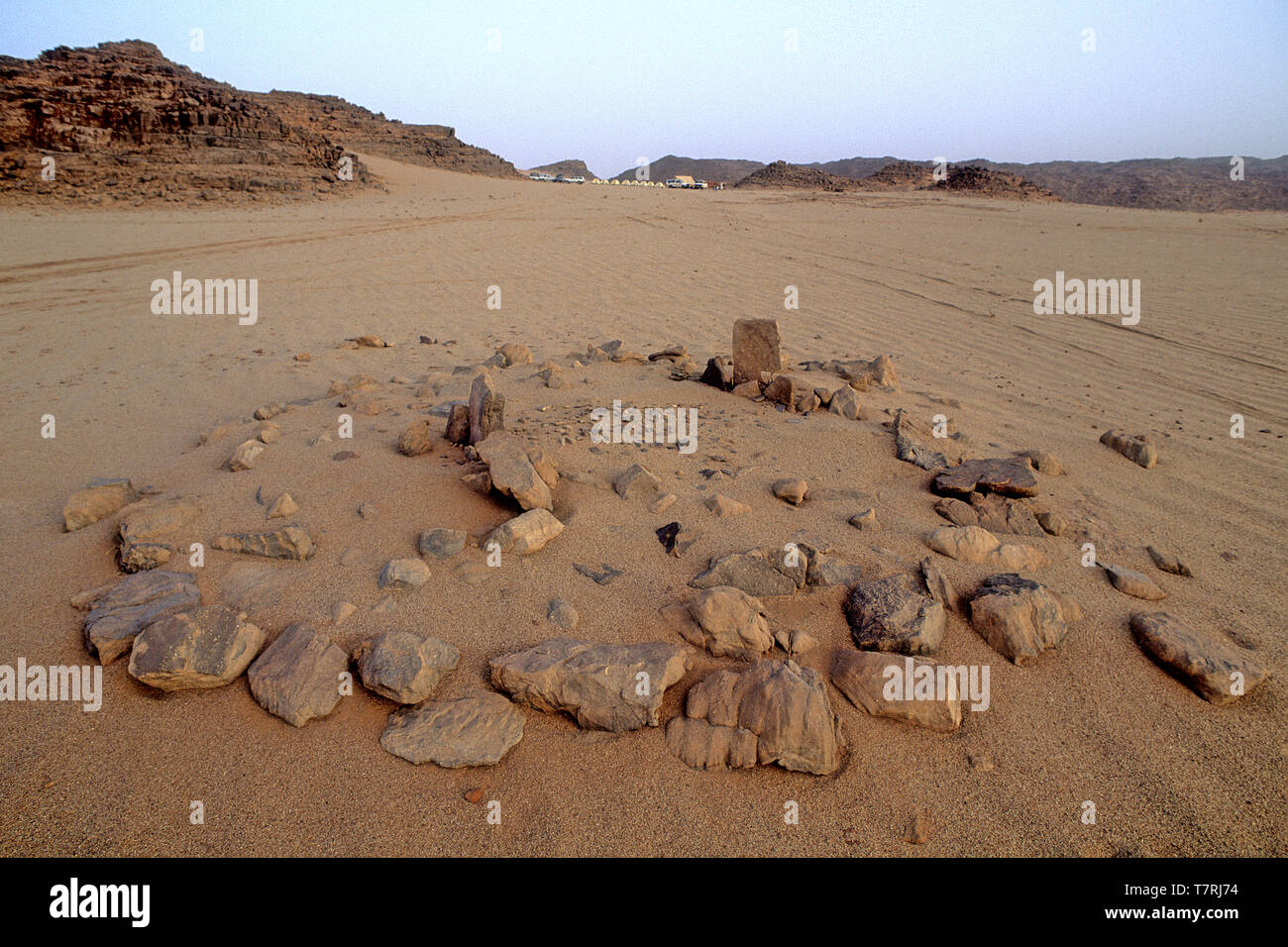 A very old primitive grave and a group setting up a camp site in the ...