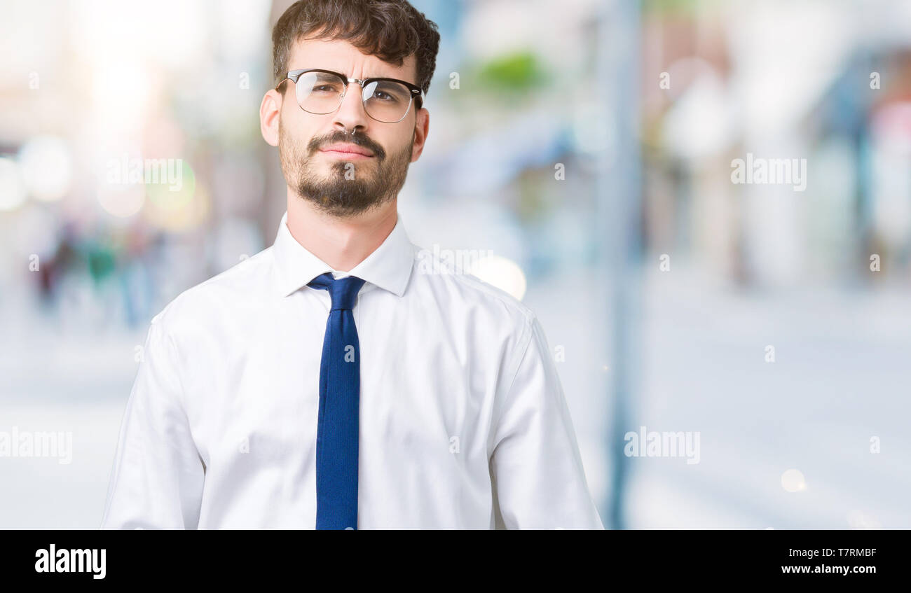 Young handsome business man wearing glasses over isolated background ...