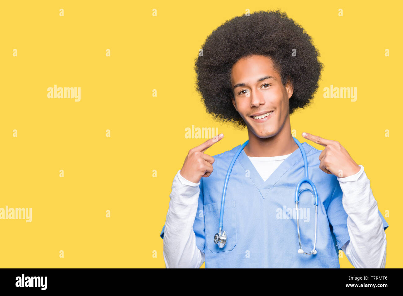Young african american doctor man with afro hair smiling confident ...