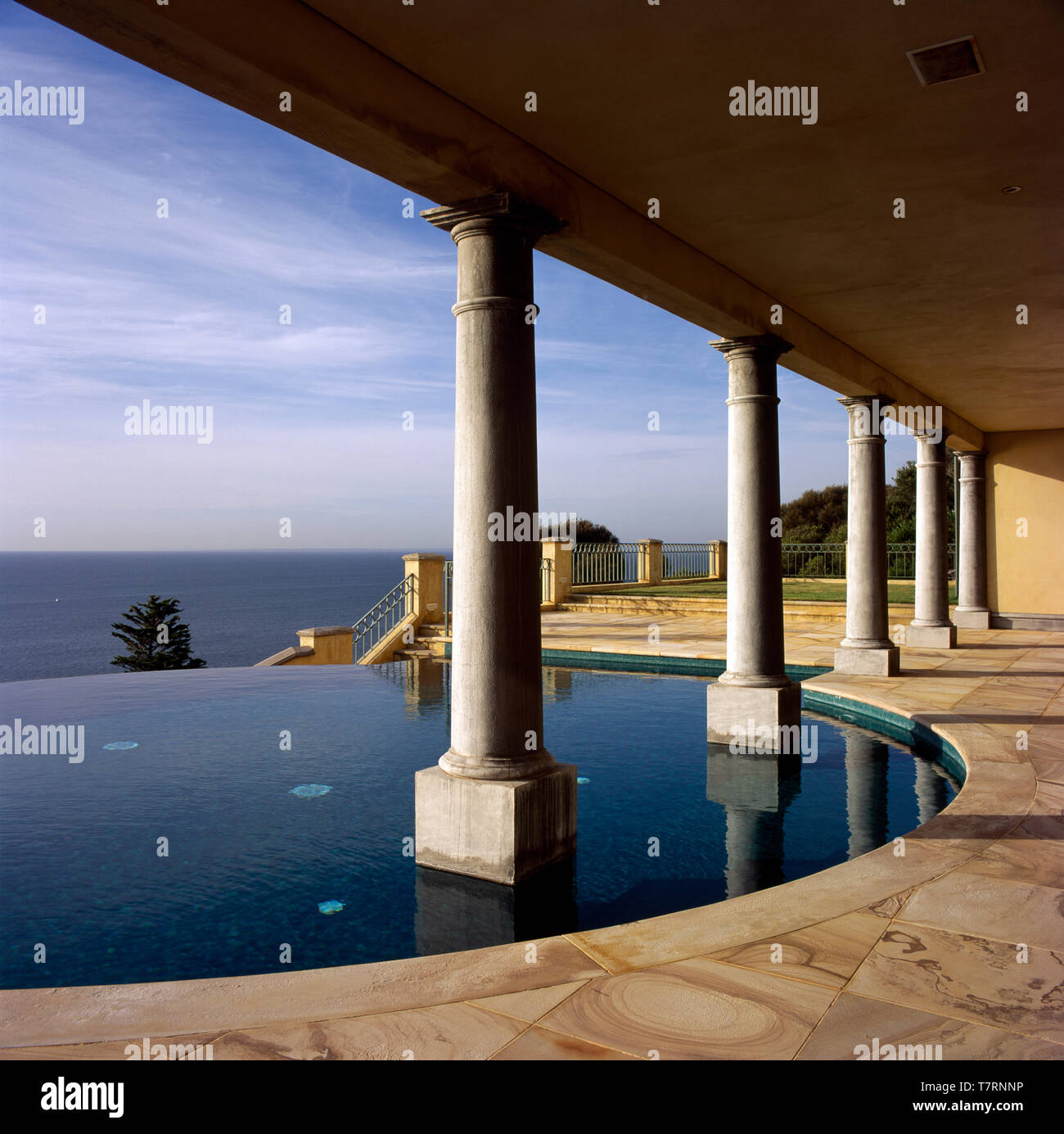 Neo-classical columns beside infinity pool in front of a coastal house ...