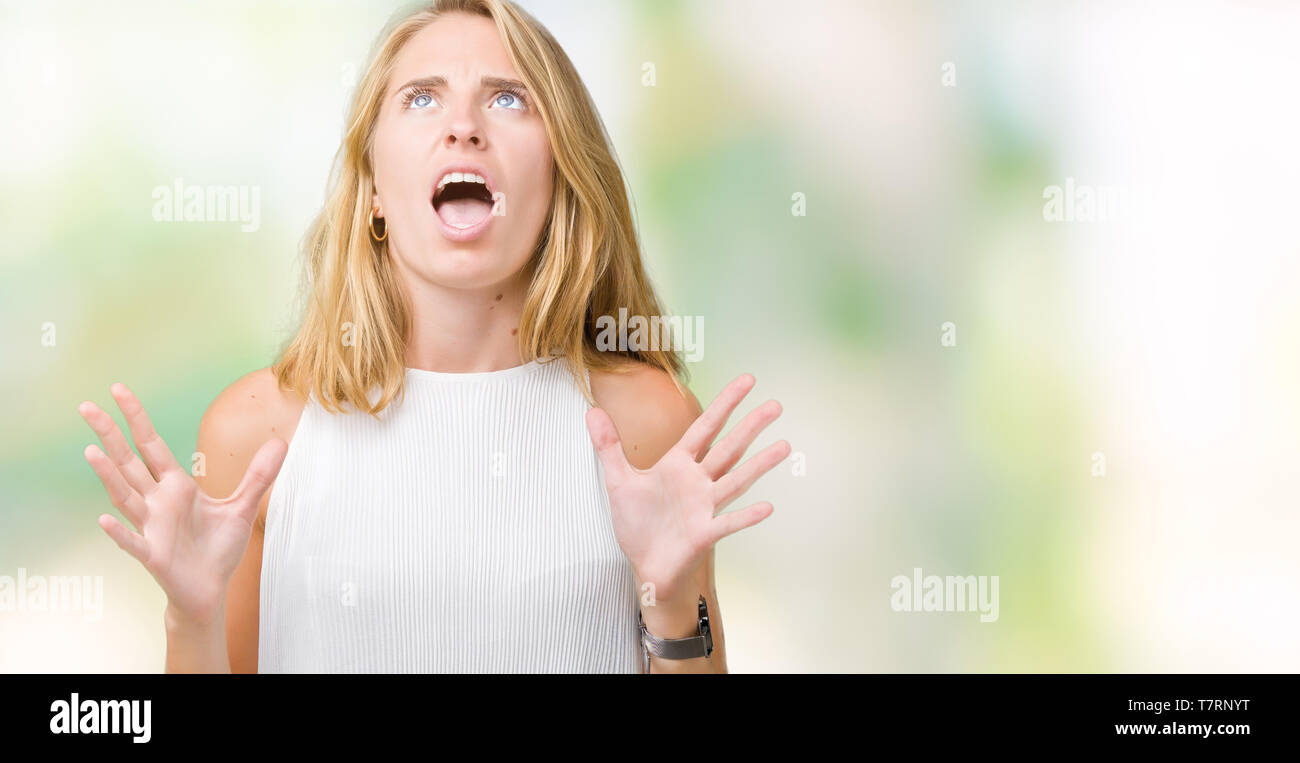 Beautiful young elegant woman over isolated background crazy and mad ...