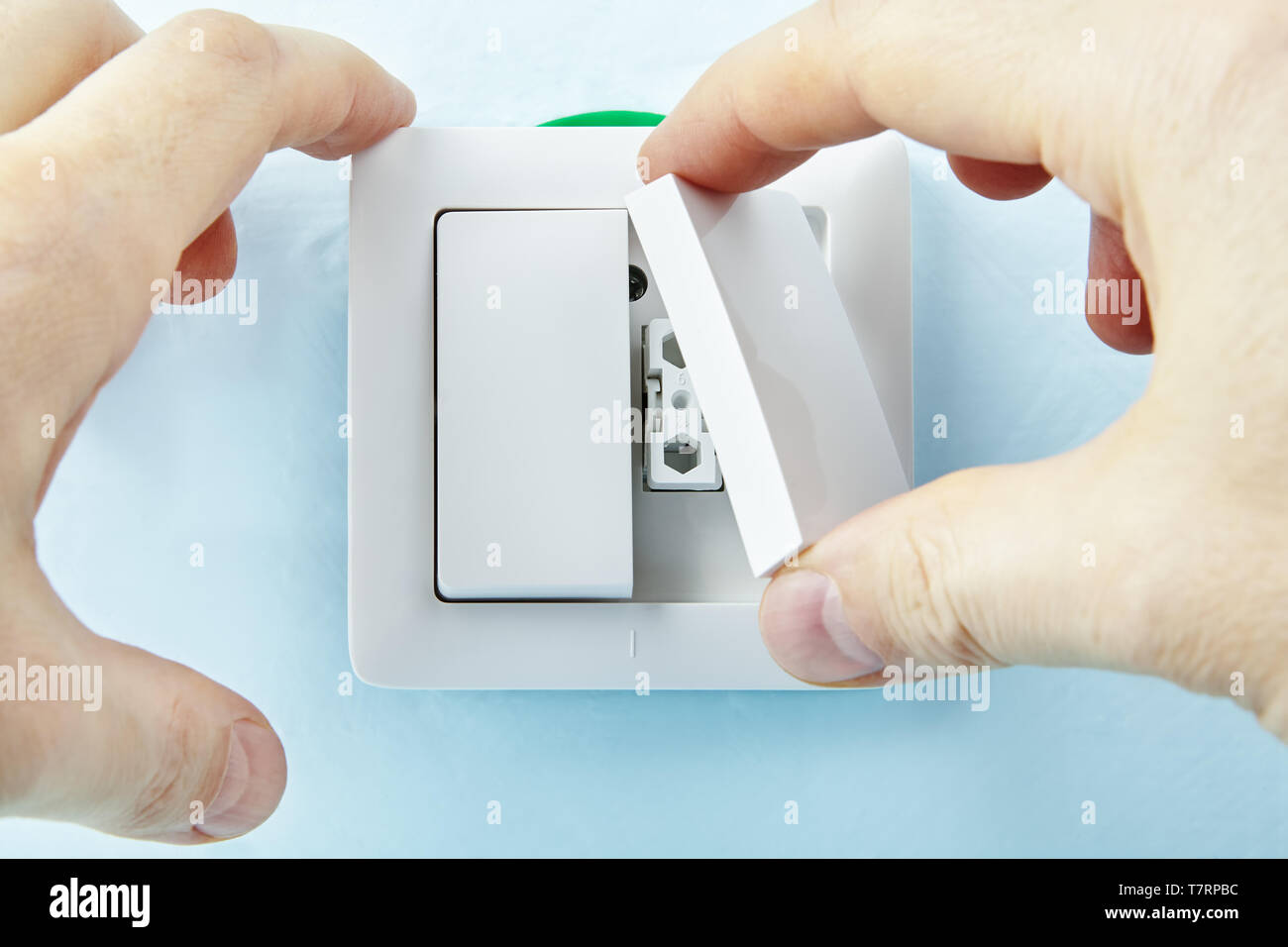 Electrician is installing new european standard light switch making new ...