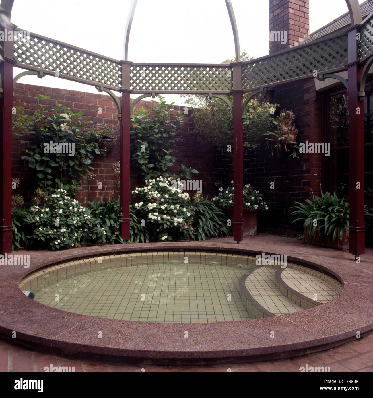 Circular jacuzzi with paved edging in small courtyard garden Stock ...