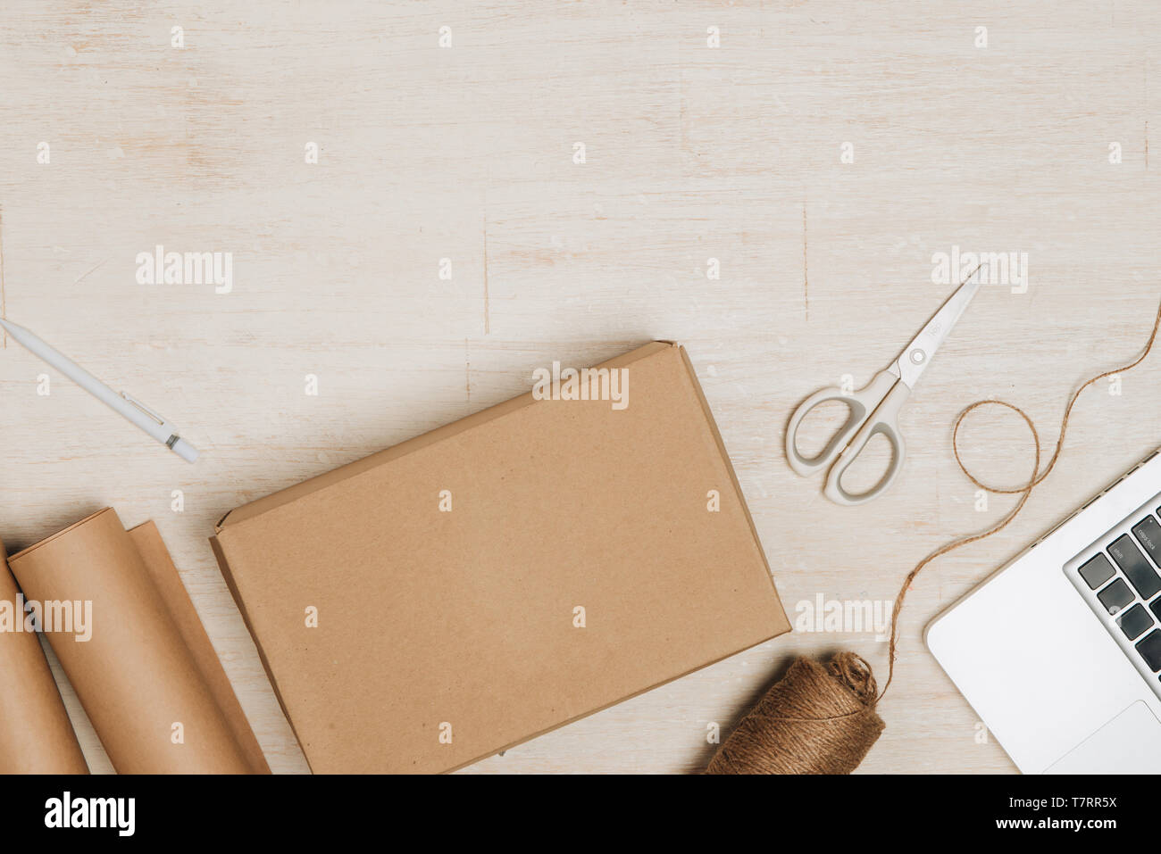 Gift boxes wrapped in kraft paper, scissors and rope Stock Photo - Alamy