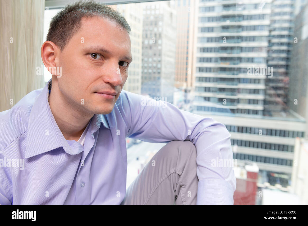 Modern buildings window and young man sitting closeup portrait of face ...