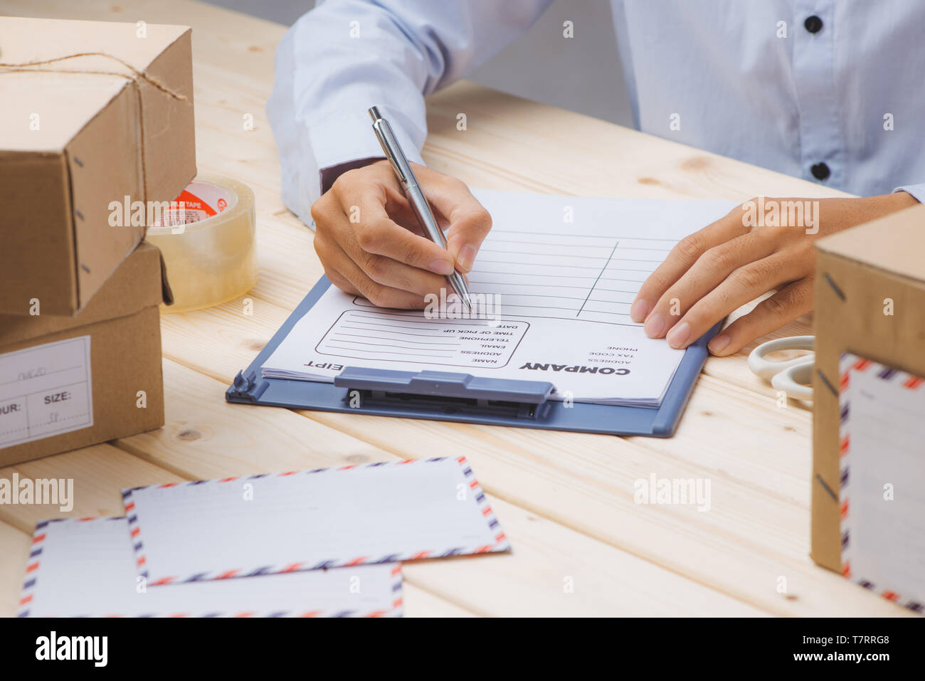 Delivery concept. Man signs papers among parcels Stock Photo - Alamy
