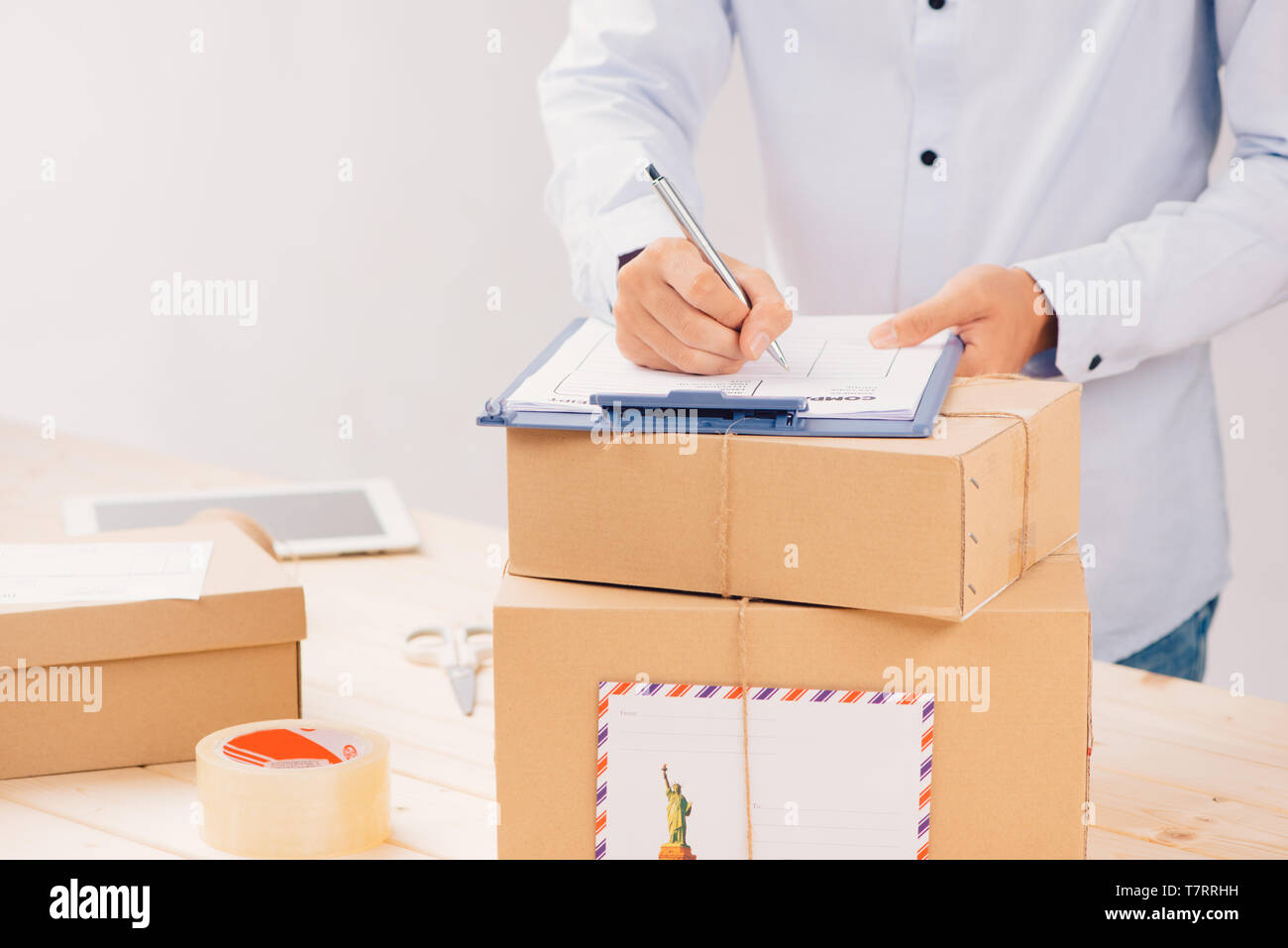 Courier hands writing in clipboard at table Stock Photo - Alamy