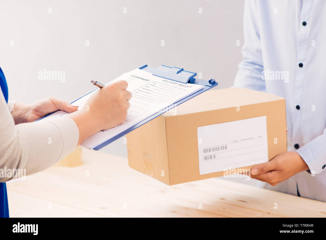 Woman customer signing receipt and receiving the parcel from delivery ...