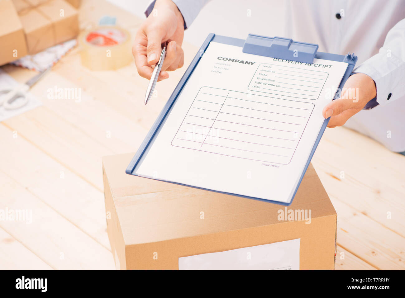 Woman customer signing receipt and receiving the parcel from delivery ...