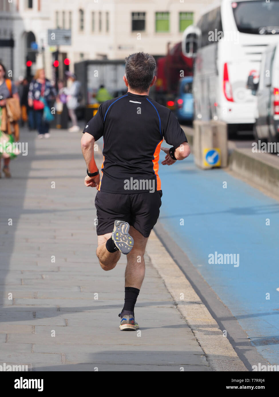 Jogger running on pavement, London, England, UK Stock Photo - Alamy