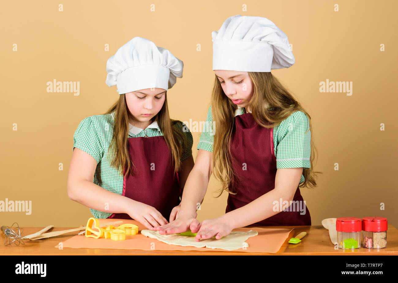 Adorable bakery ladies. Cute little girls kneading dough in bakery shop ...
