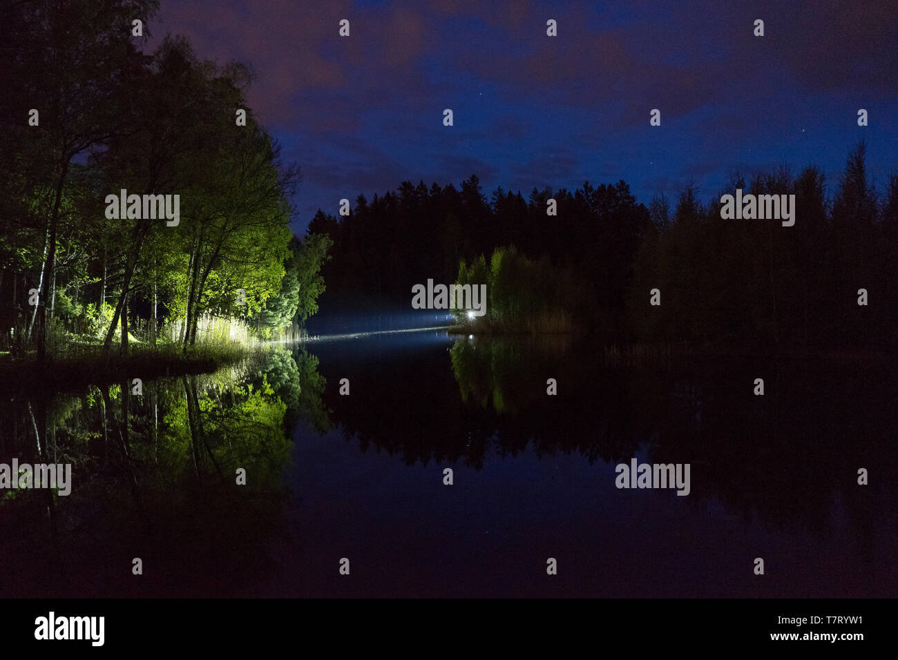 Man standing outdoor at dark night shining with flashlight. Mystical ...