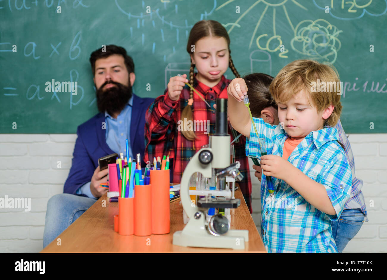 Pupil looking through microscope at the elementary school ...