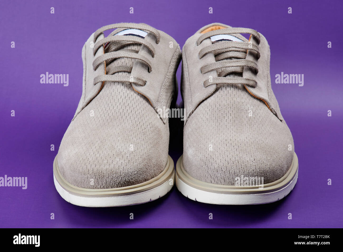 Pair of classic gray man shoes front view isolated on purple background ...