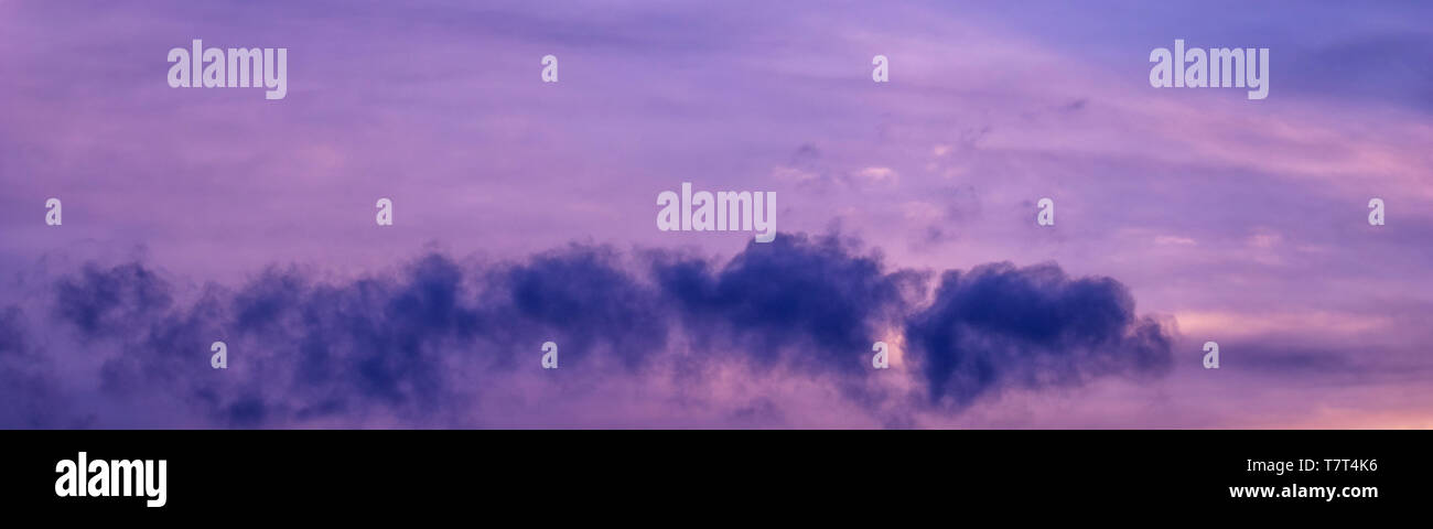 Panoramic sky at dusk with dark violet foreground clouds and purple ...