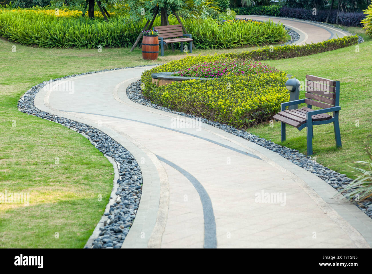 Beautiful summer garden with a walkway winding its way through. The ...