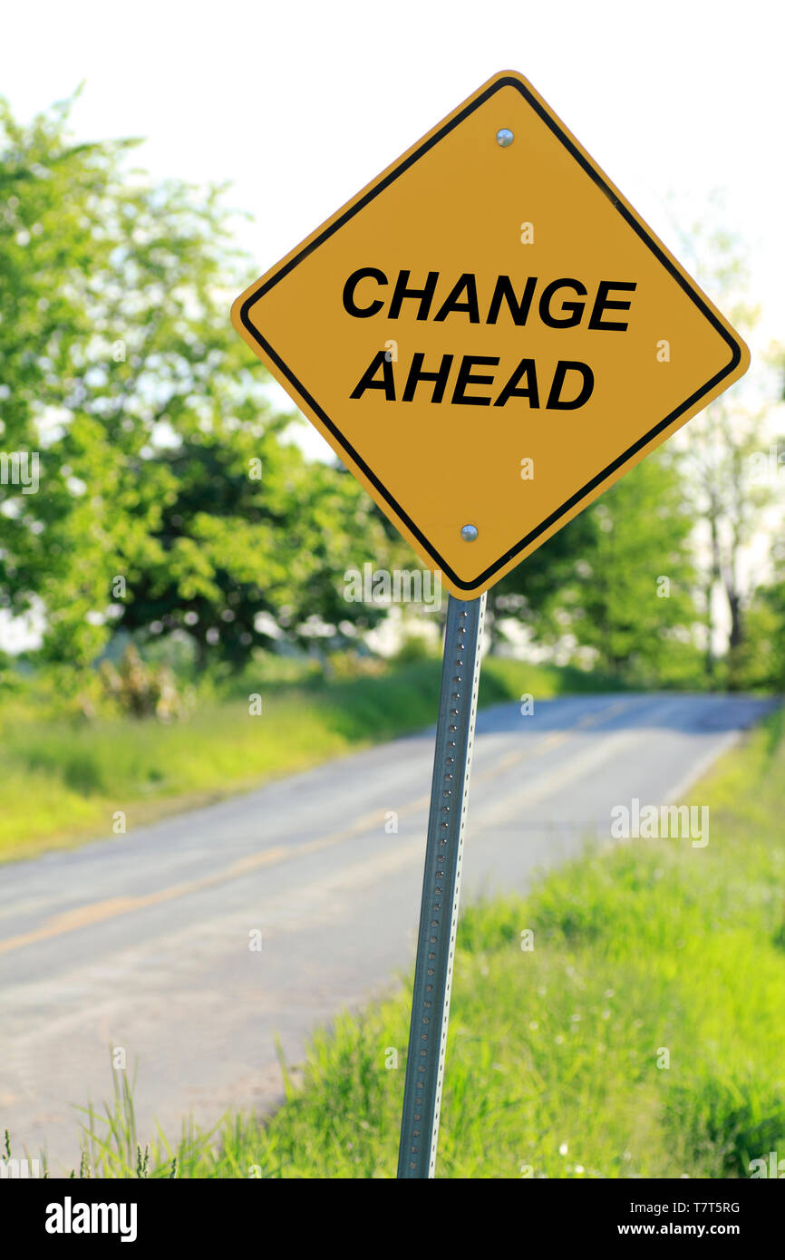 A yellow caution road sign that says "CHANGE AHEAD". The sign is a ...