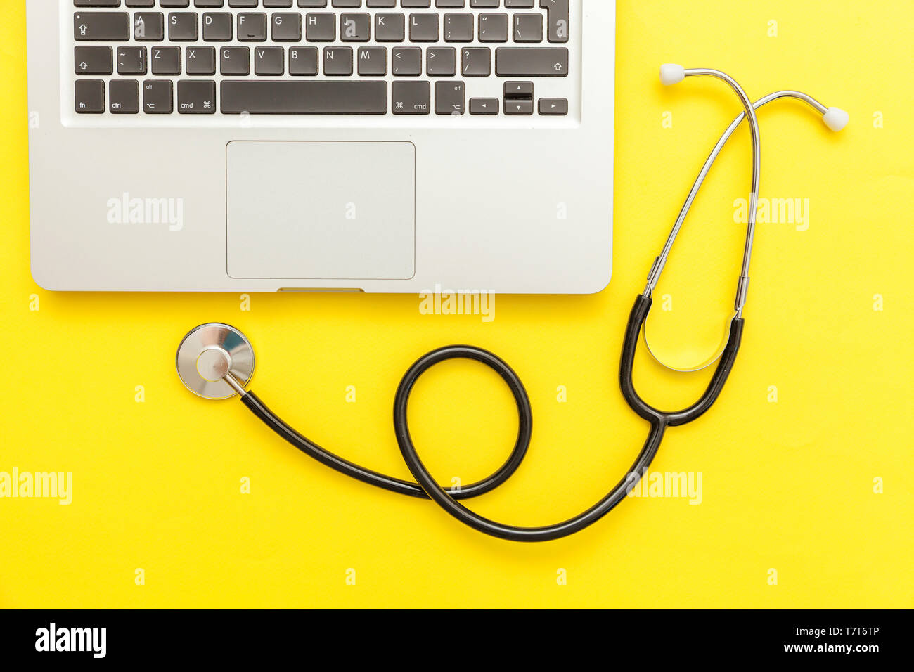 Stethoscope keyboard laptop computer isolated on yellow background ...