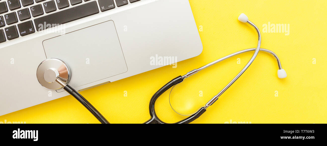 Stethoscope keyboard laptop computer isolated on yellow background ...
