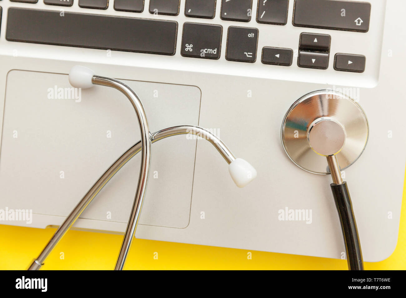 Stethoscope keyboard laptop computer isolated on yellow background ...