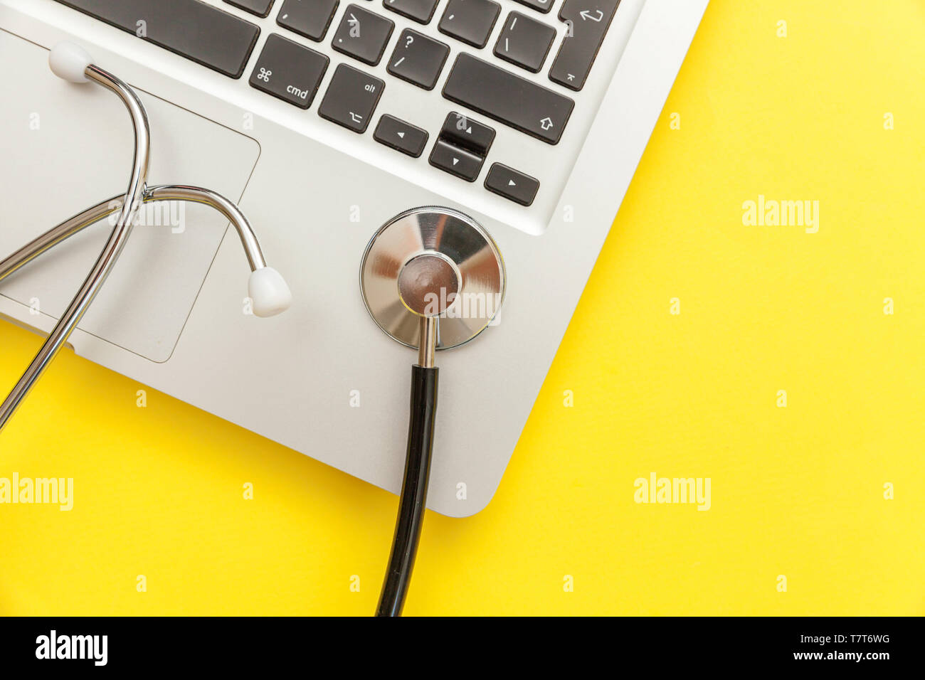 Stethoscope keyboard laptop computer isolated on yellow background ...