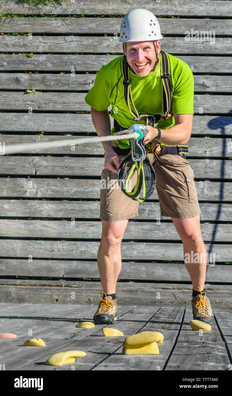 Man has fun during abseiling training at climbing wall Stock Photo - Alamy