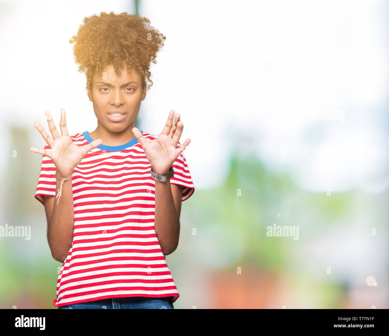 Beautiful young african american woman over isolated background afraid ...