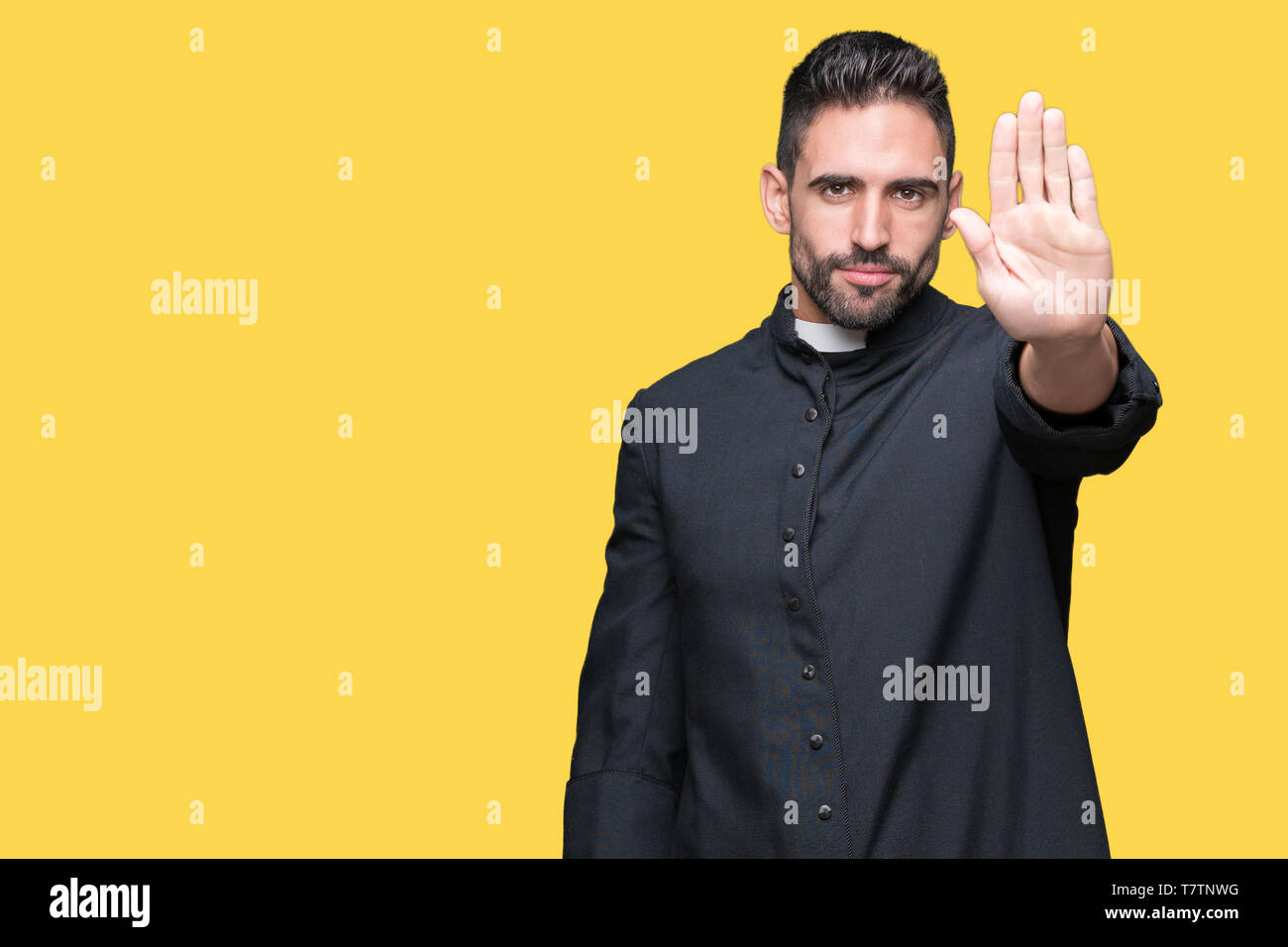 Young Christian priest over isolated background doing stop sing with ...
