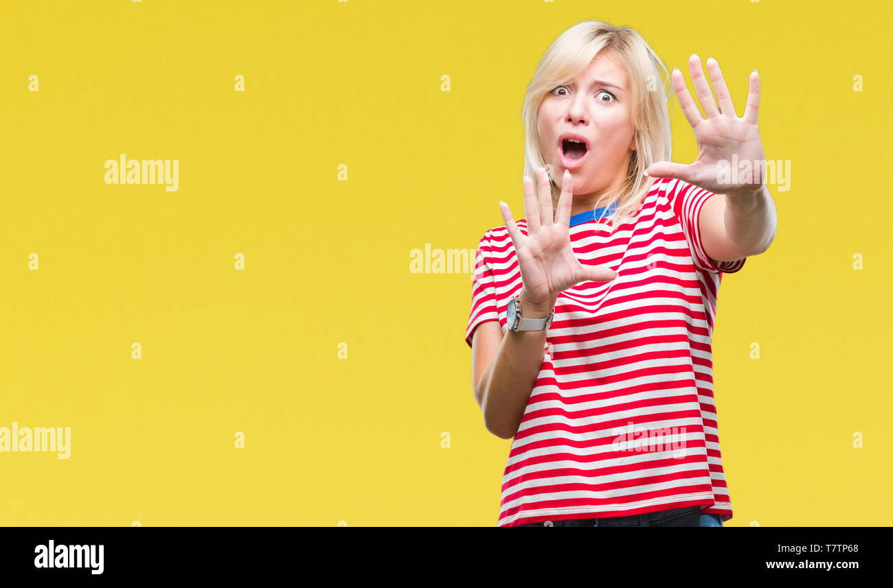 Young beautiful blonde woman over isolated background afraid and ...