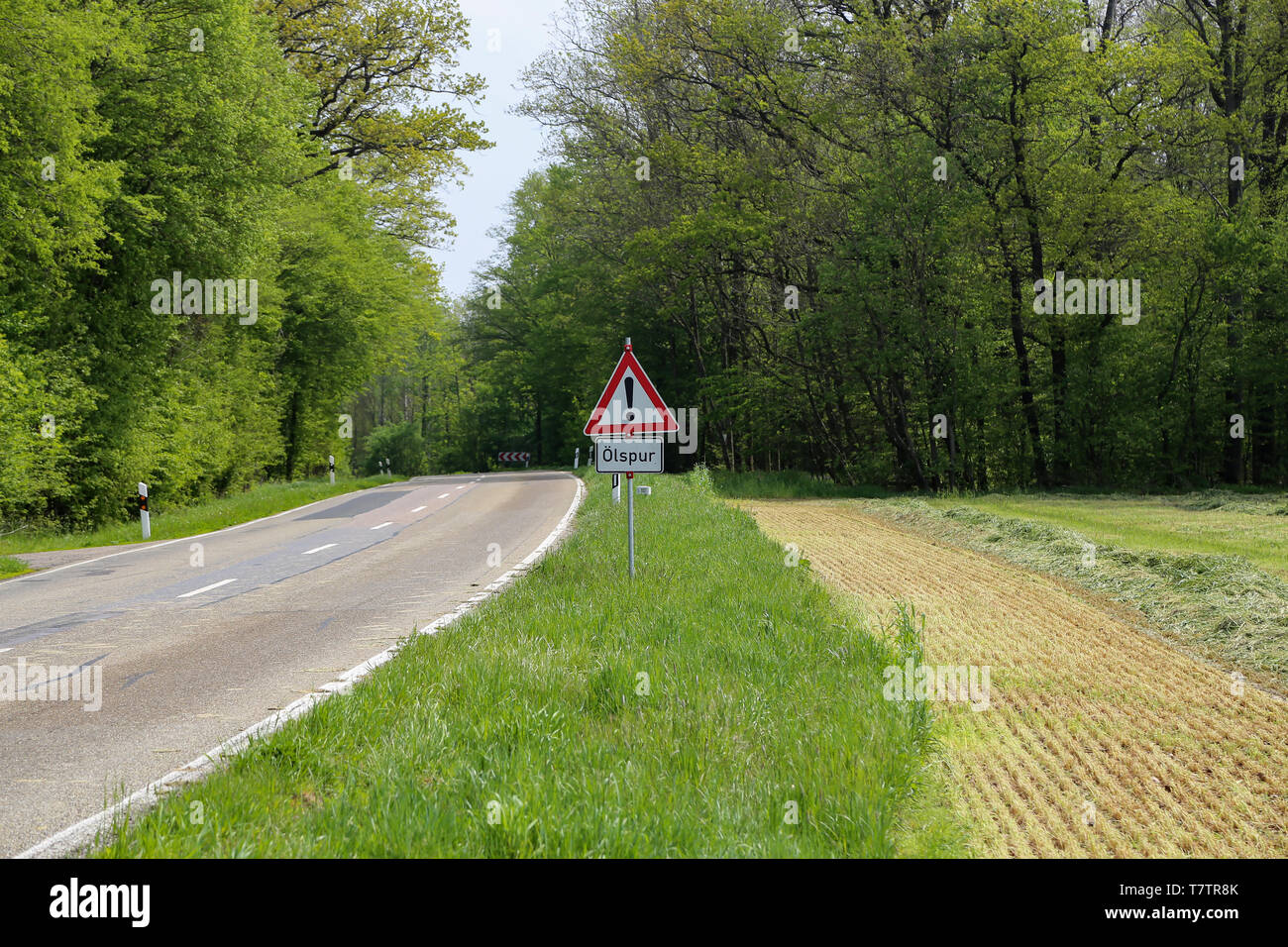 Warning road sign on the edge of the road. German text: oil track Stock ...