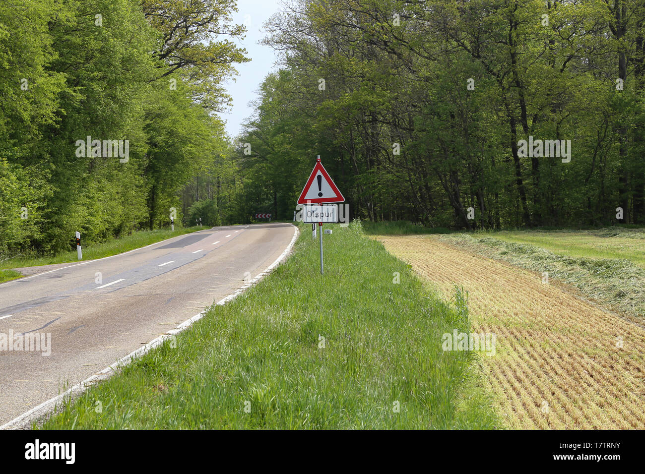 Warning road sign on the edge of the road. German text: oil track Stock ...
