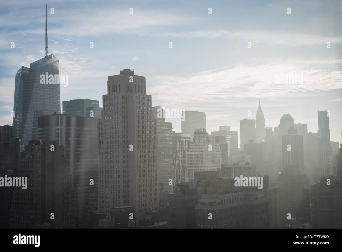 Blue sunrise with dazzling sun rays over New York from a high floor of ...