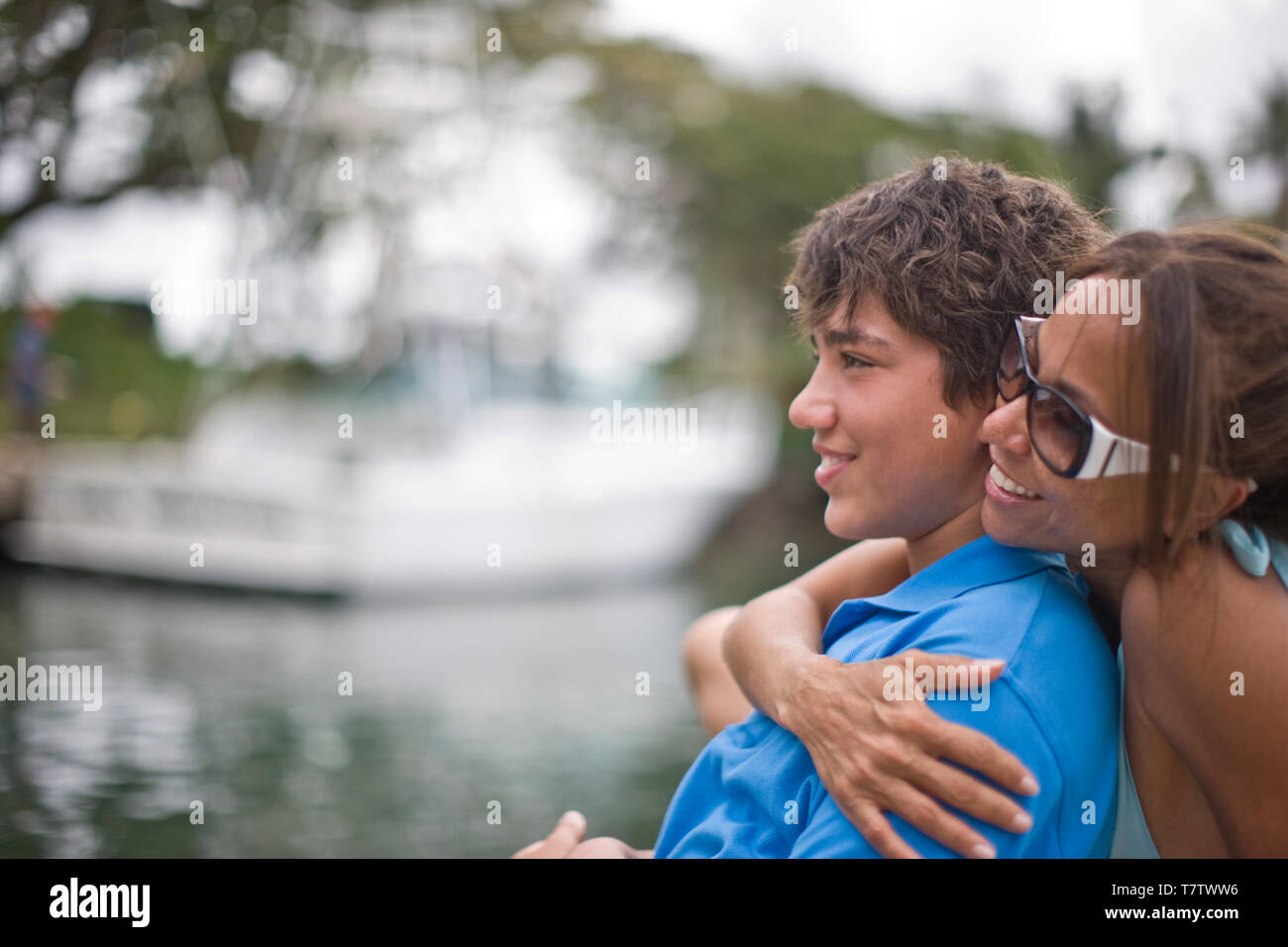 Smiling mother hugging her teenage son from behind Stock Photo - Alamy