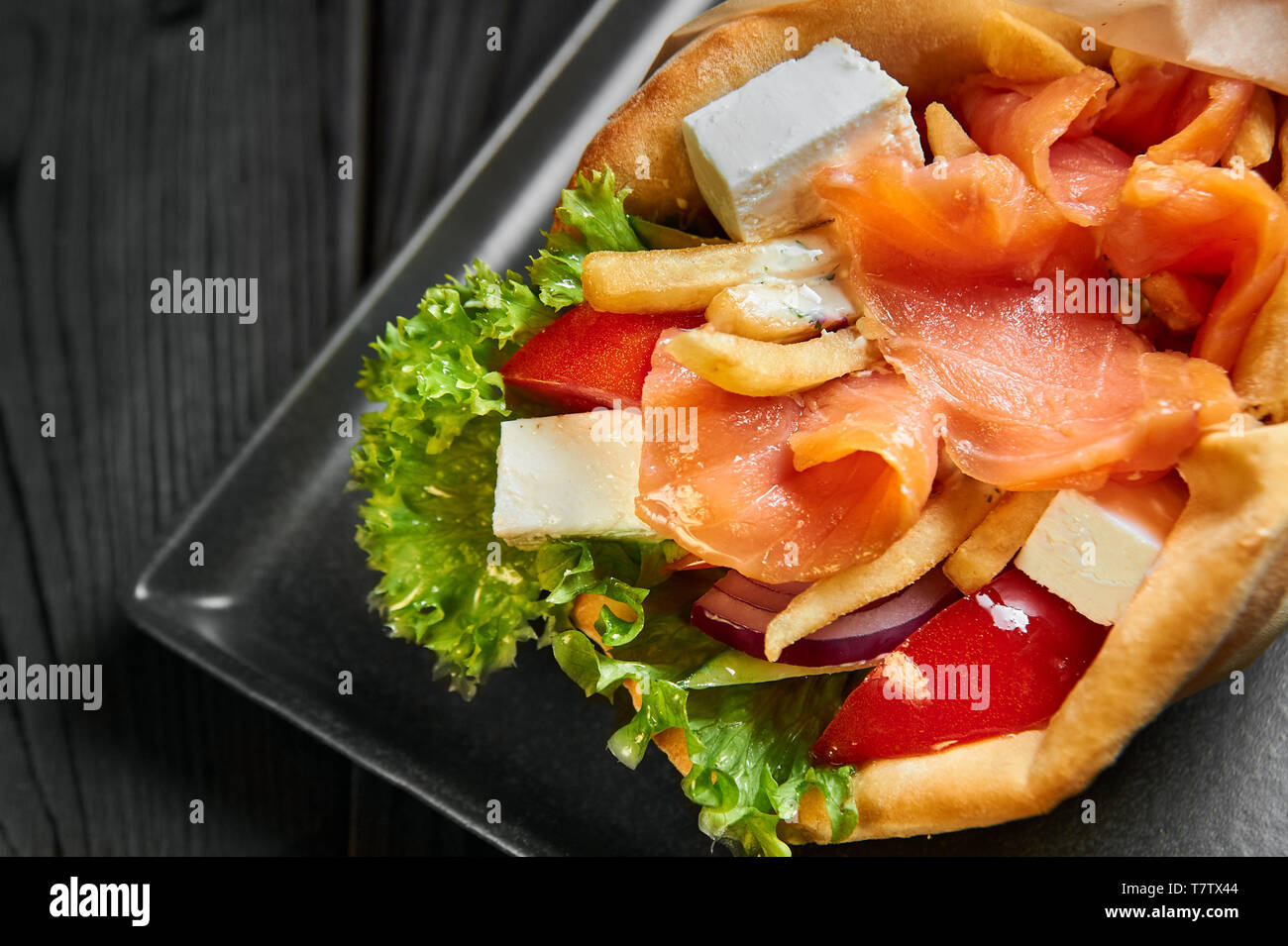 gyro in pita with salmon fish, vegetables and feta. Traditional Greek ...