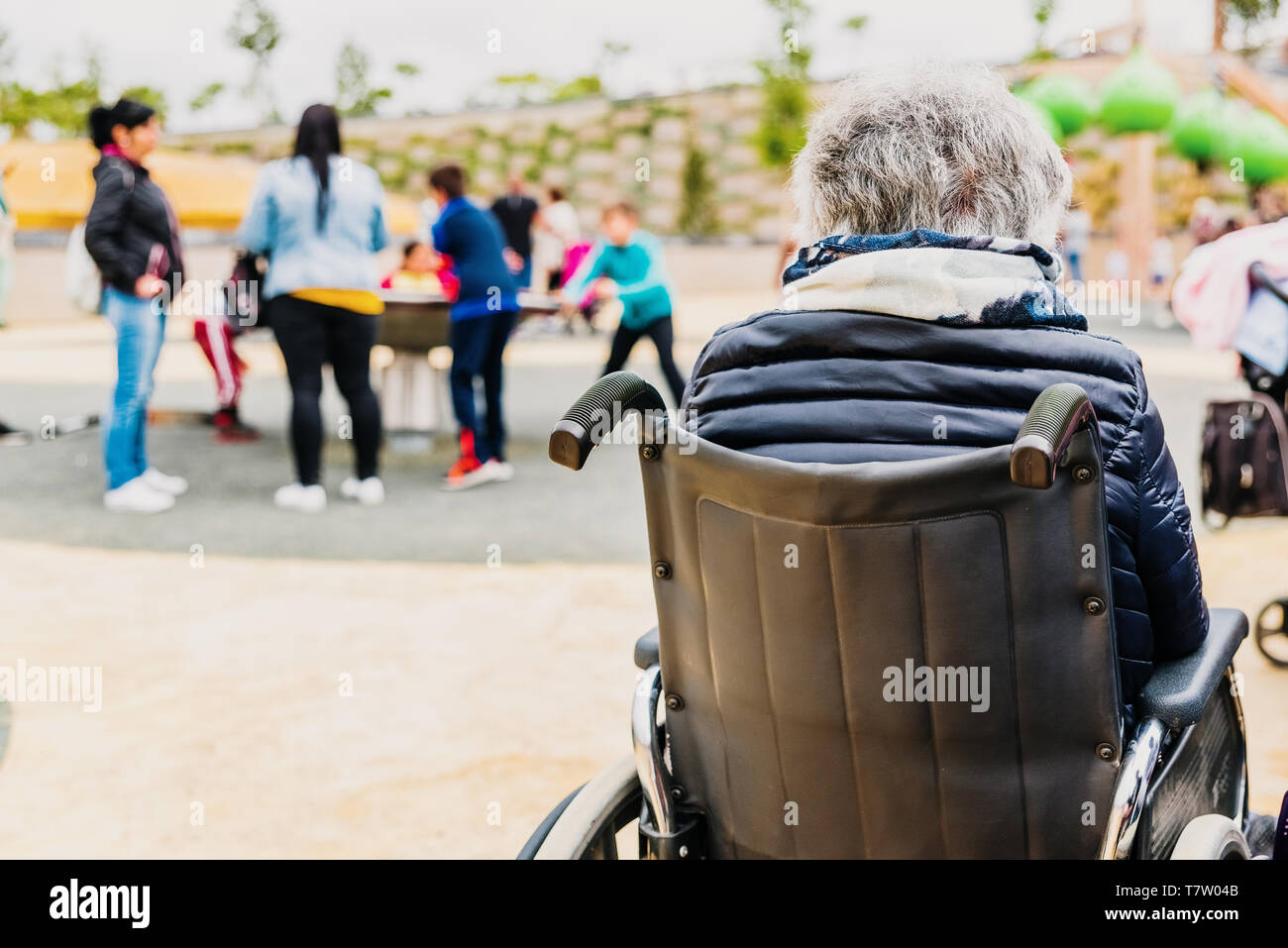Elderly disabled woman sitting back to back in a wheelchair in a ...
