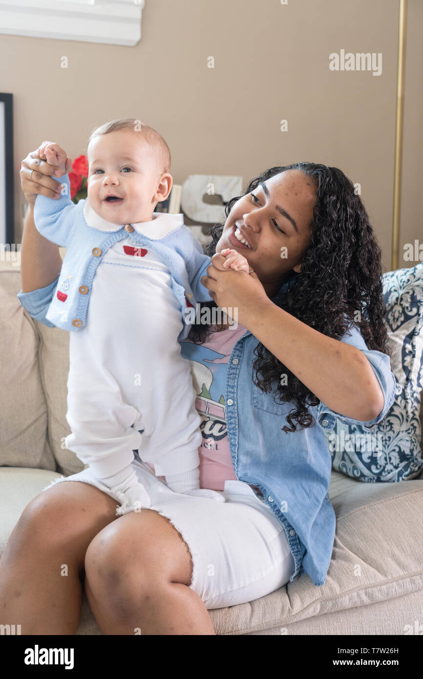sister (15 years old) holds her baby brother (6 monthes old) in her ...