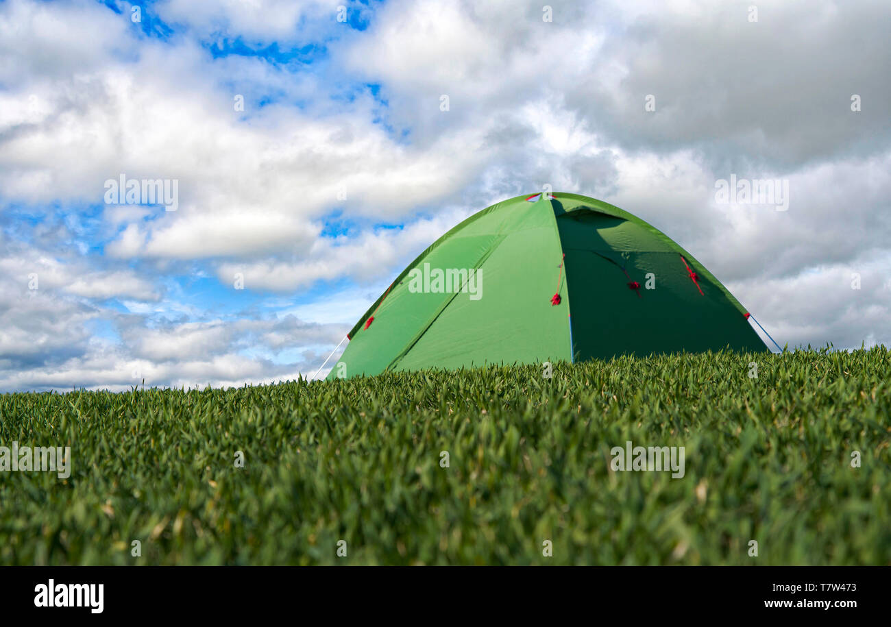 Tourist tent. Camping on the grass in sun Stock Photo - Alamy
