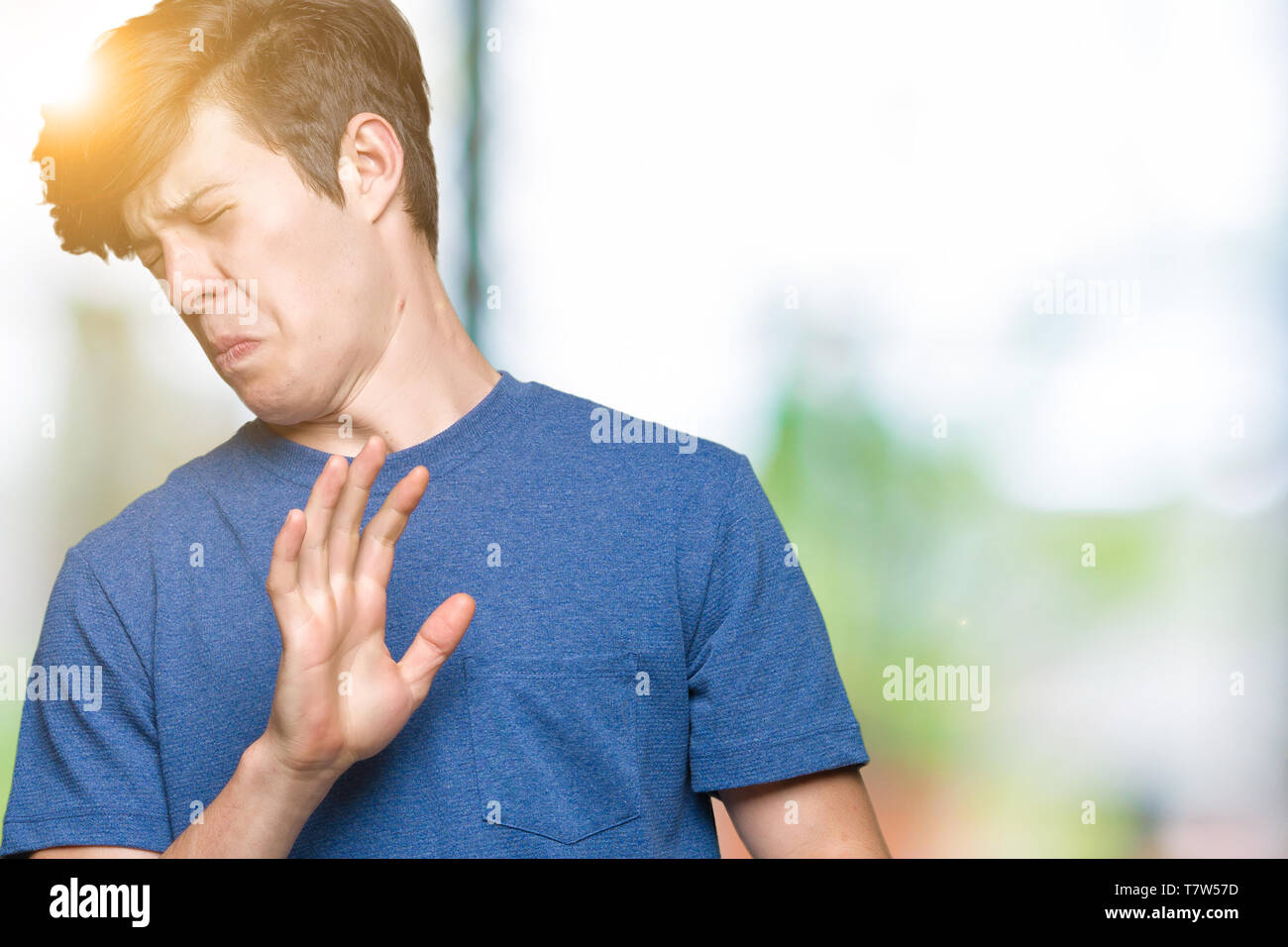 Young handsome man wearing blue t-shirt over isolated background ...