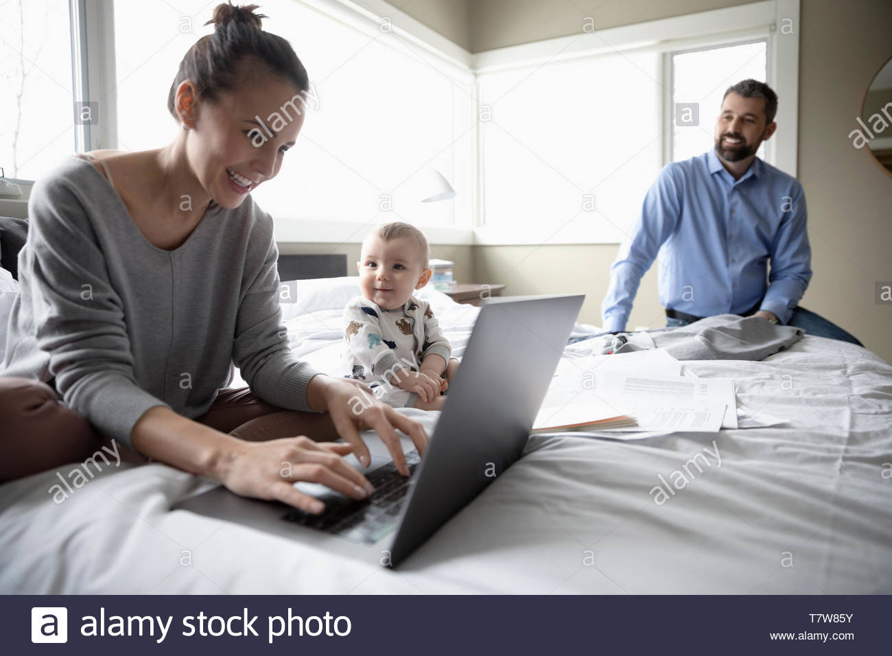 Parents with baby son working from home and getting ready for work in ...