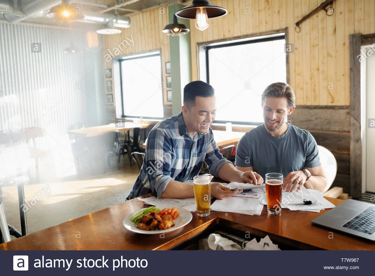 Male business owners working and drinking beer in brewhouse Stock Photo ...