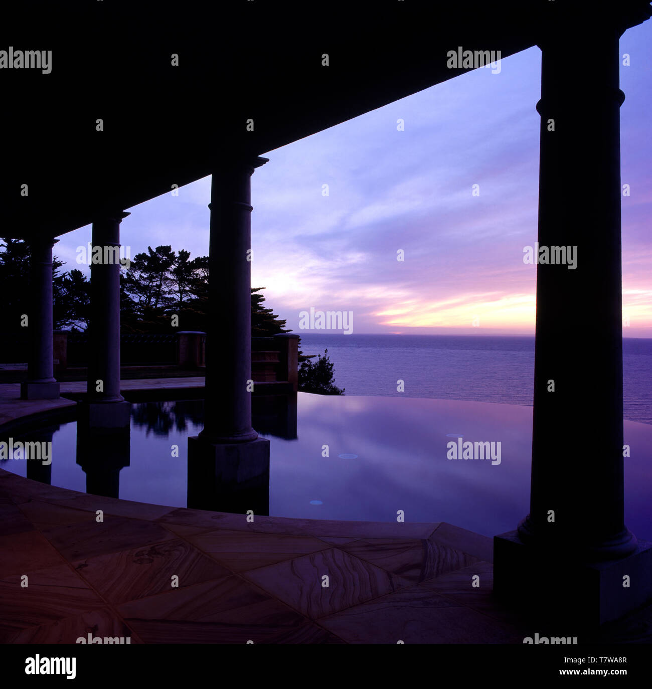 Neo-classical columns beside infinity pool in front of a coastal house ...