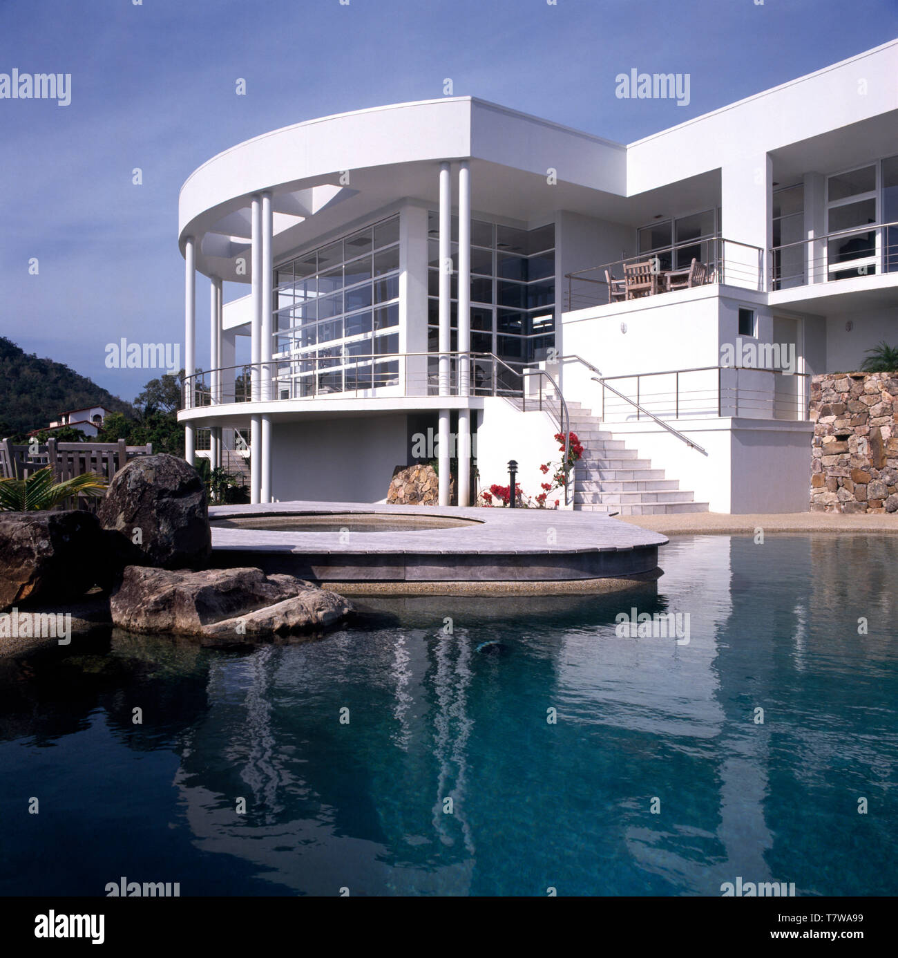 Swimming pool in front of a large modern coastal house Stock Photo - Alamy