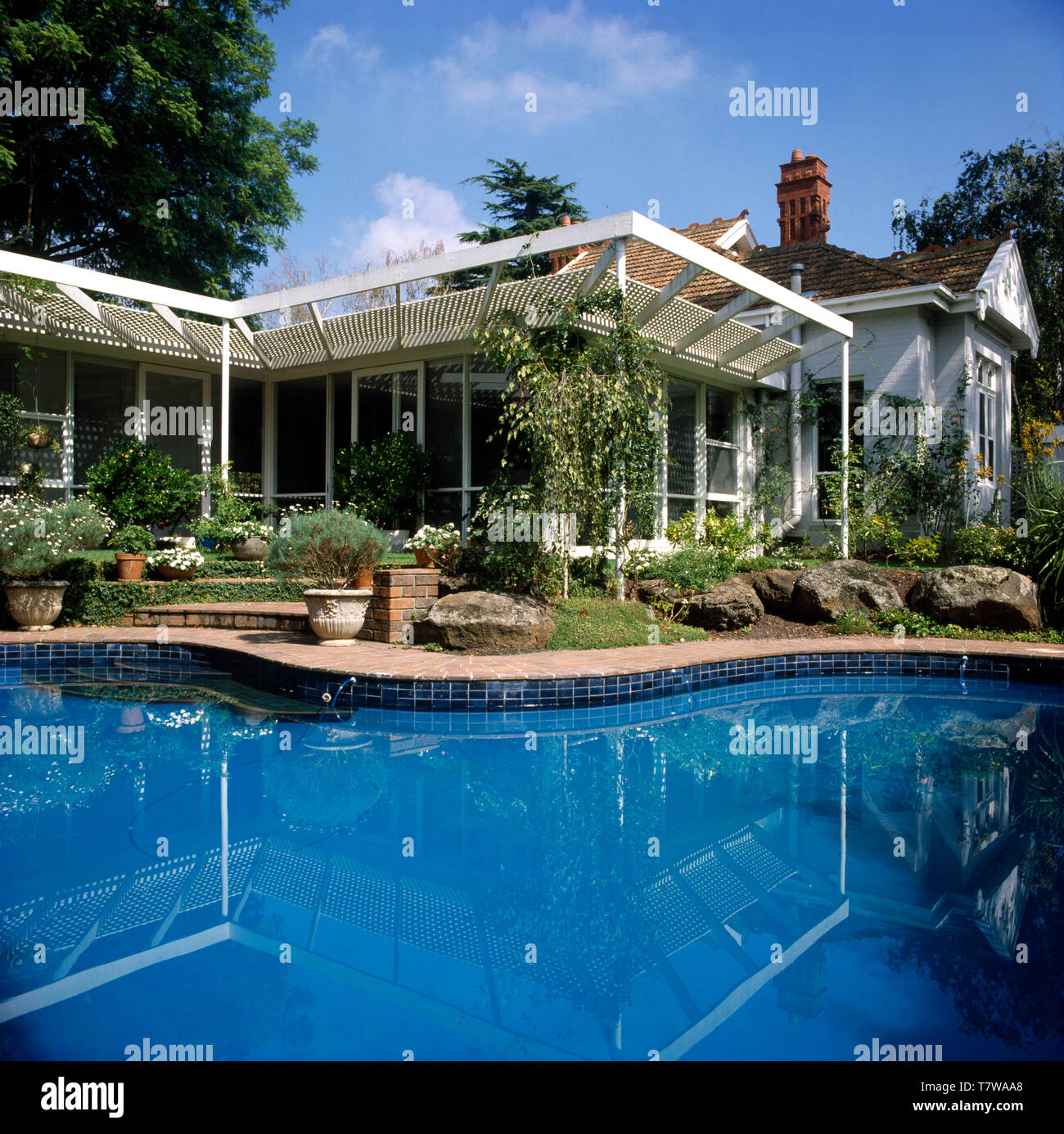 Swimming pool in front of a modern extension on a traditional house ...