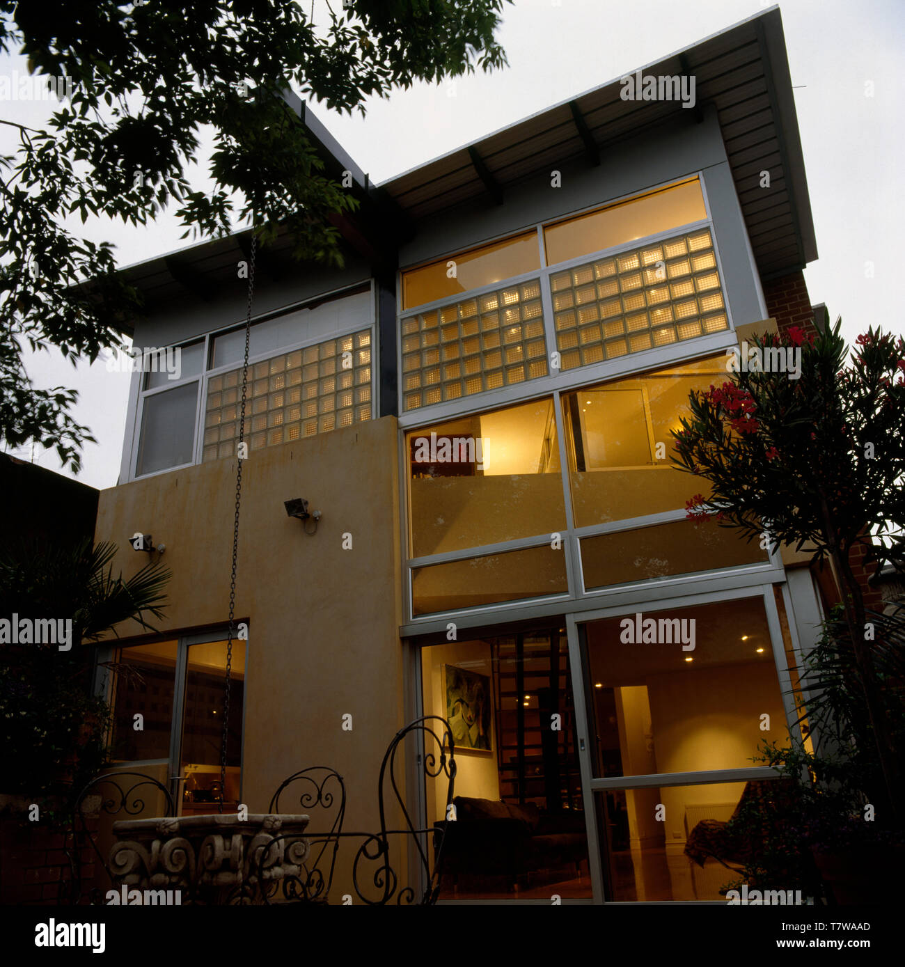 Exterior of a modern yellow house lit from within Stock Photo - Alamy