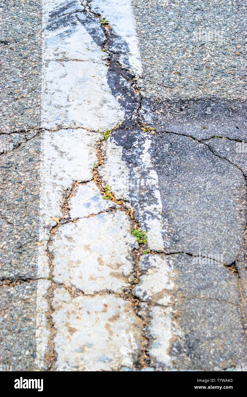 Cracks on asphalt concrete road with white line Stock Photo - Alamy