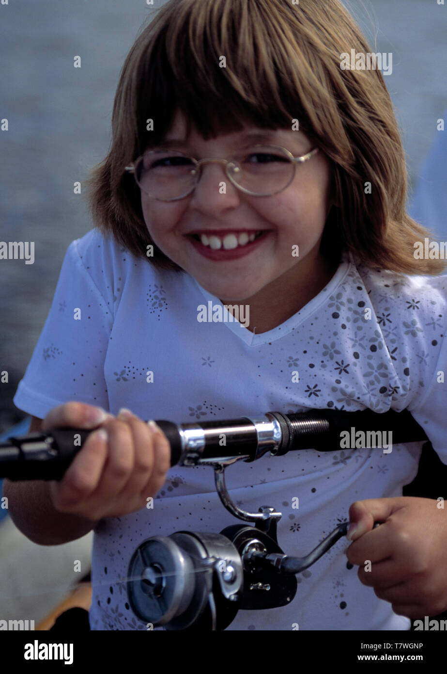 young girl showing her great personality holding a fishing rod on a ...