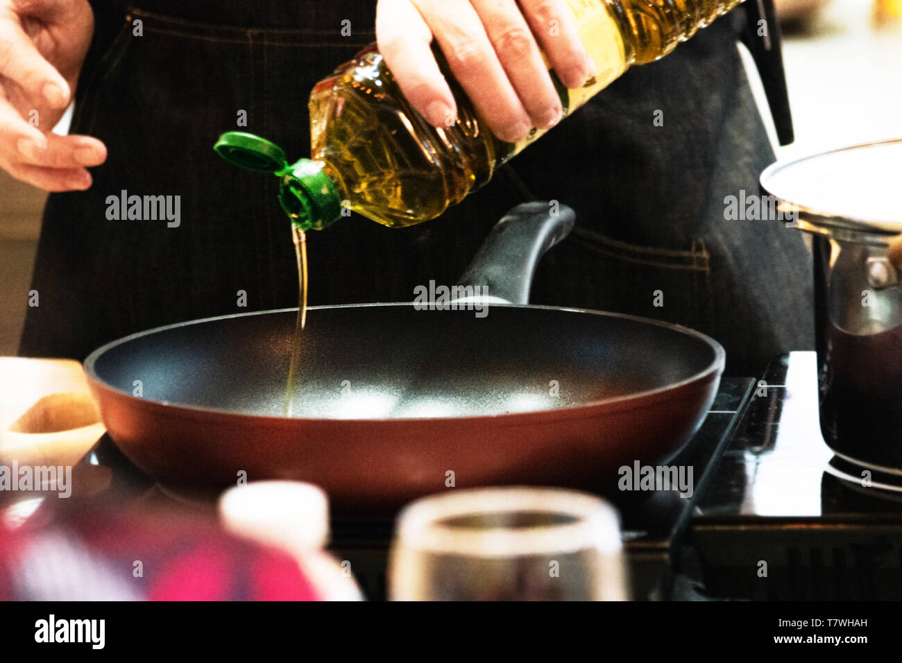 Chef pouring oil in frying pan, Chef cooking food in the kitchen Stock ...