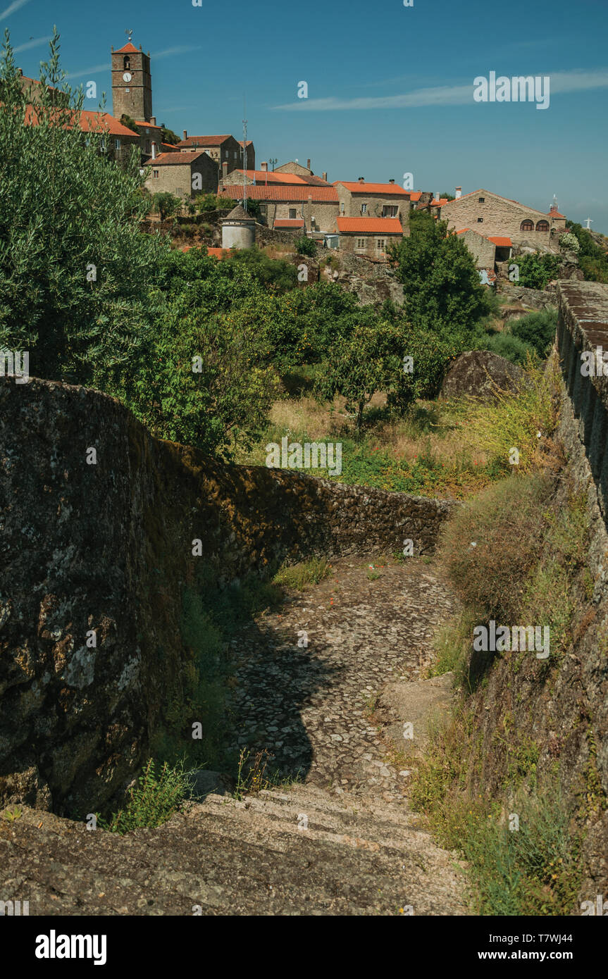 Stone pathway with steps in front of the Monsanto village, with steeple ...