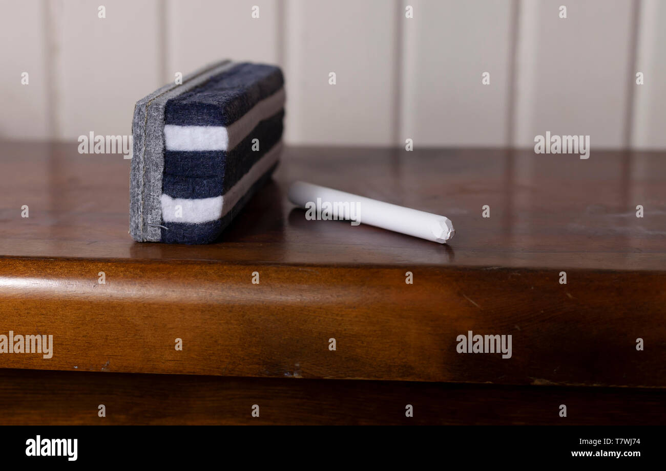 Eraser and a single piece of chalk on a table Stock Photo - Alamy