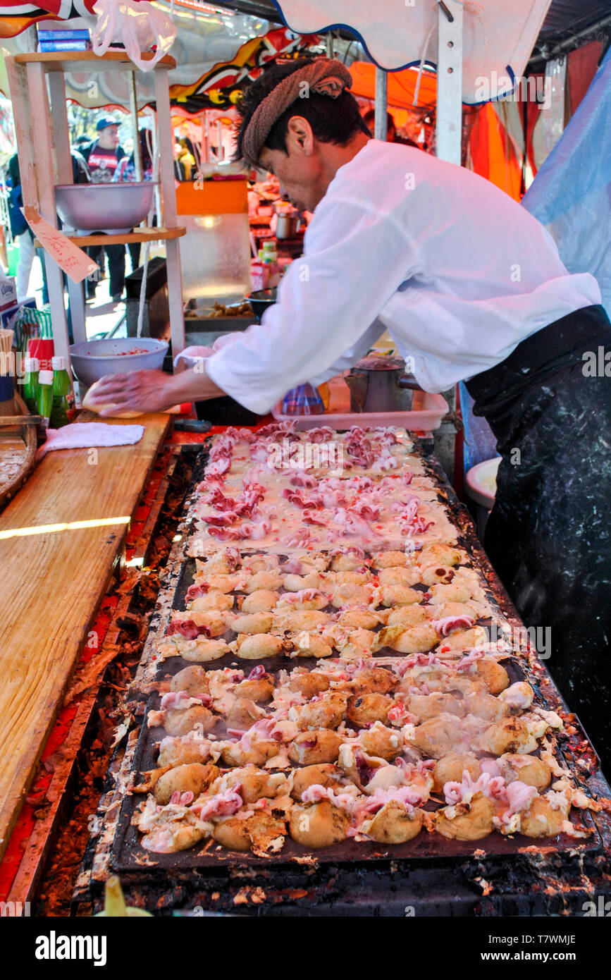 A man cooking octopus takoyakis outside of Sensō-ji temple. Asakusa ...